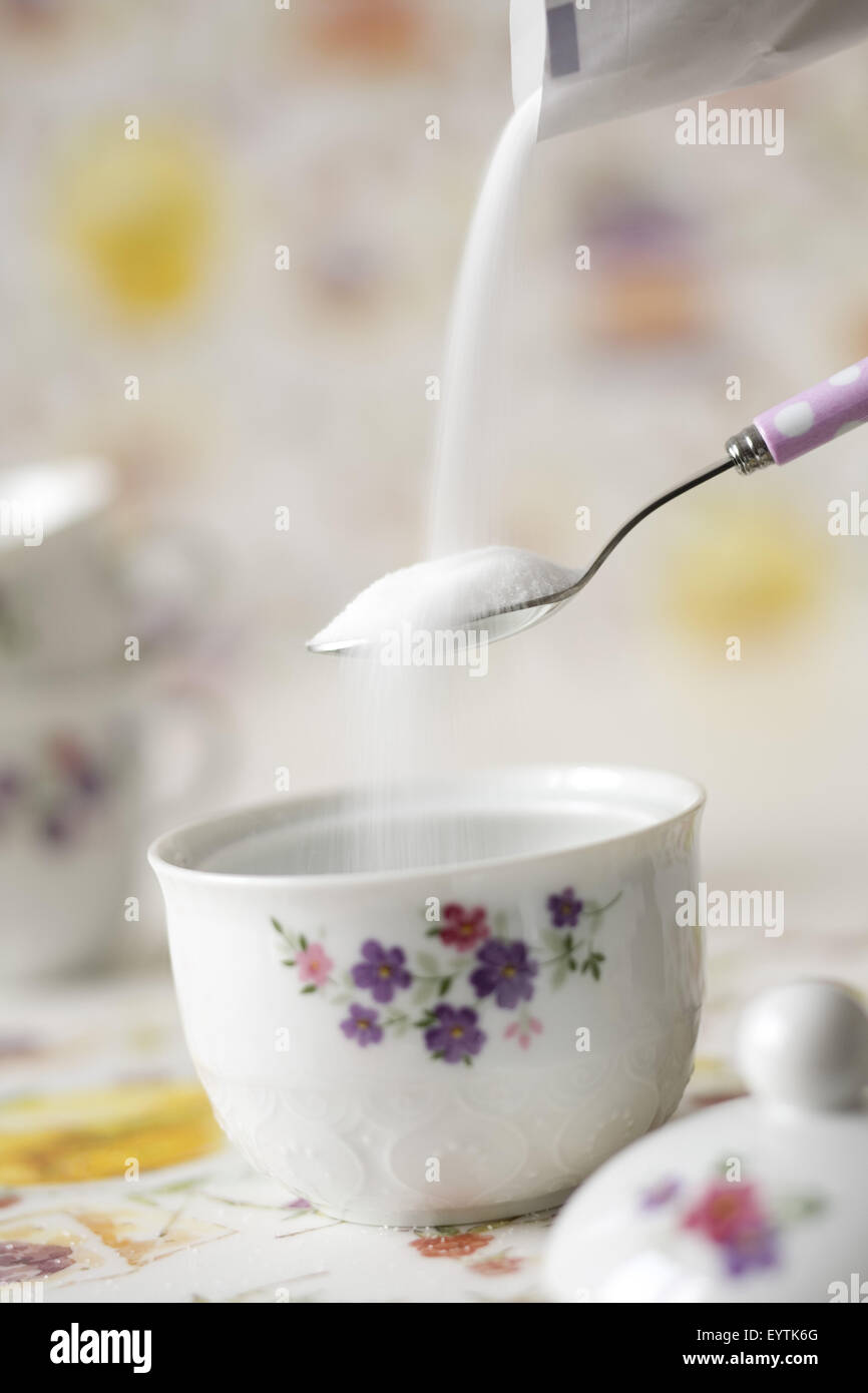 Sugar spilling over spoon Stock Photo - Alamy