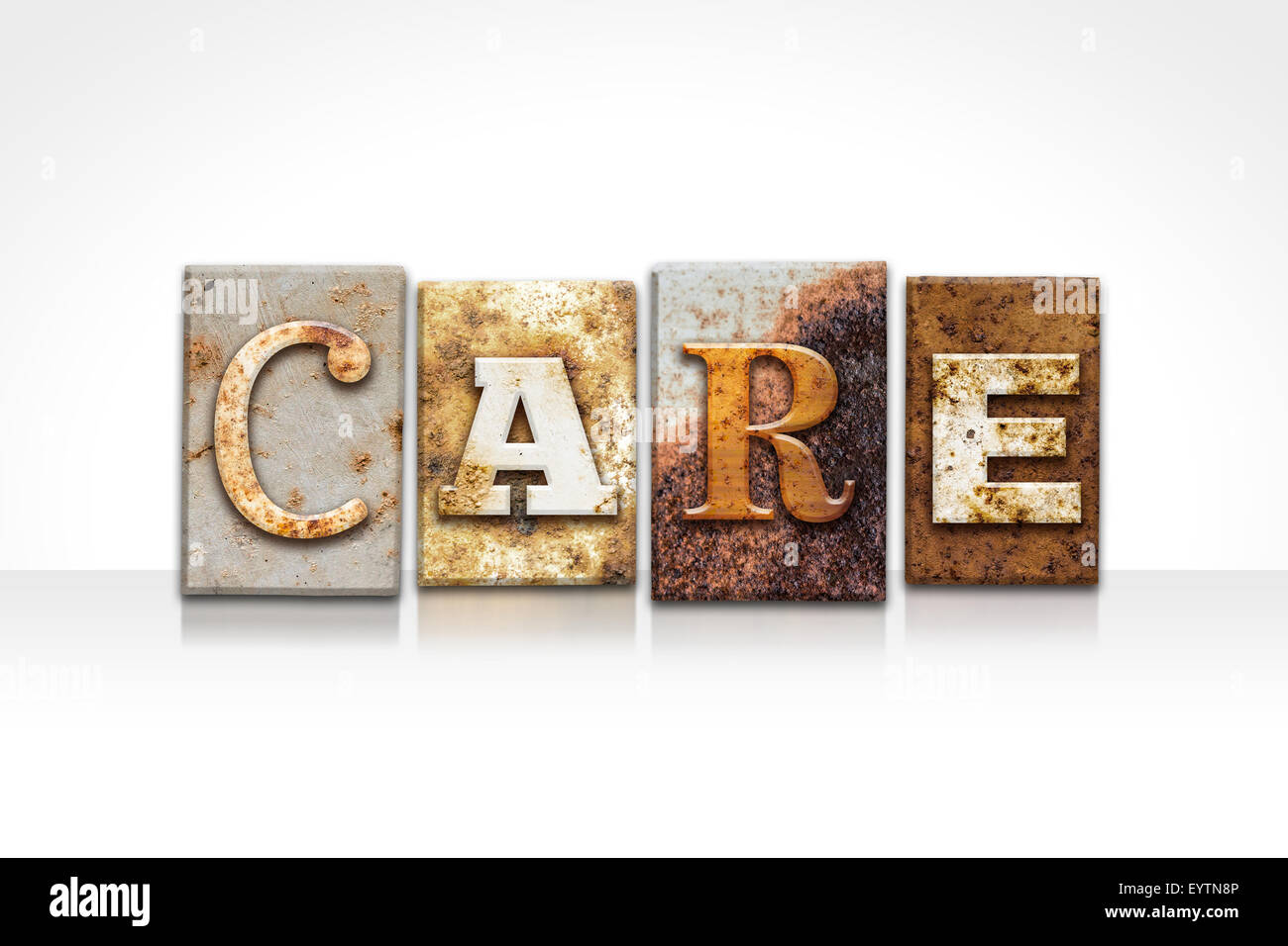 The word "CARE" written in rusty metal letterpress type isolated on a ...
