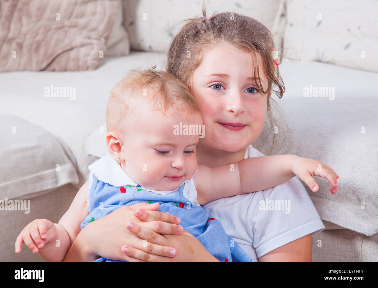 Big sister holding her 1 year old baby sister Stock Photo - Alamy