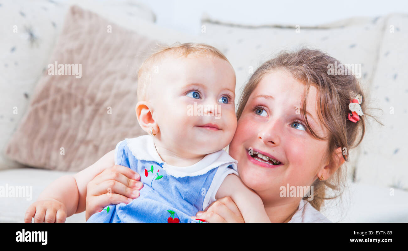 Big sister holding her 1 year old baby sister Stock Photo - Alamy