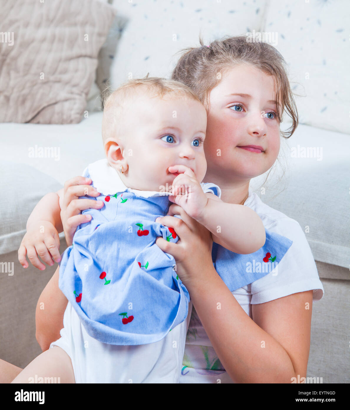 Big sister holding her 1 year old baby sister Stock Photo - Alamy