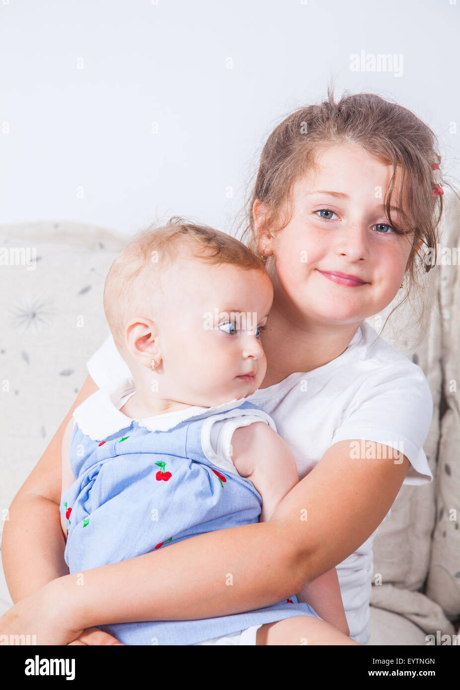 Big sister holding her 1 year old baby sister Stock Photo - Alamy