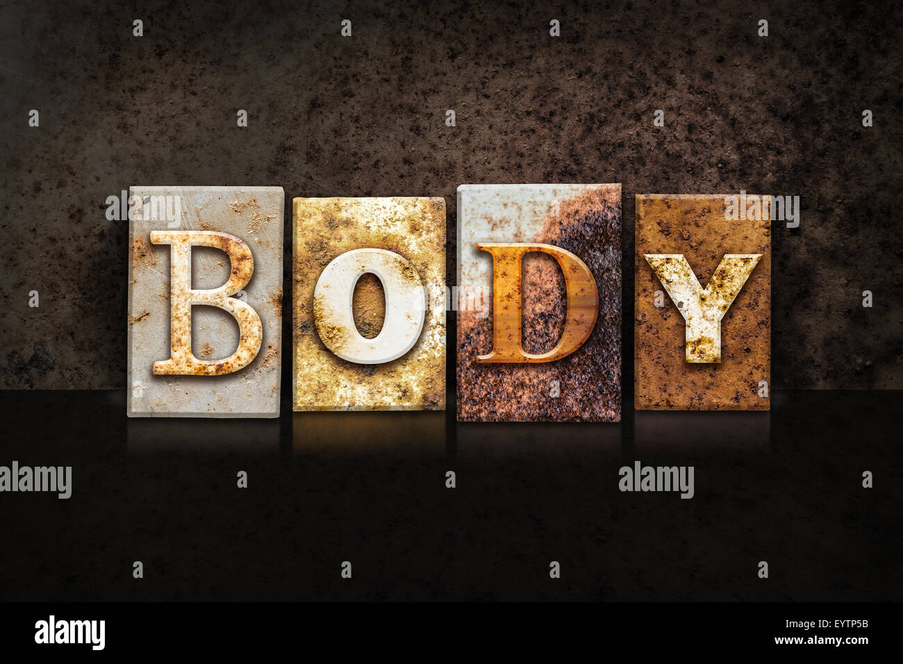 The word "BODY" written in rusty metal letterpress type on a dark ...