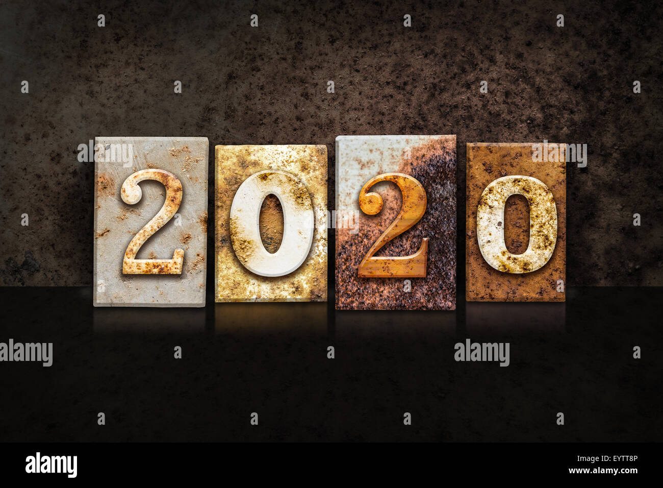 The word "2020" written in rusty metal letterpress type on a dark ...