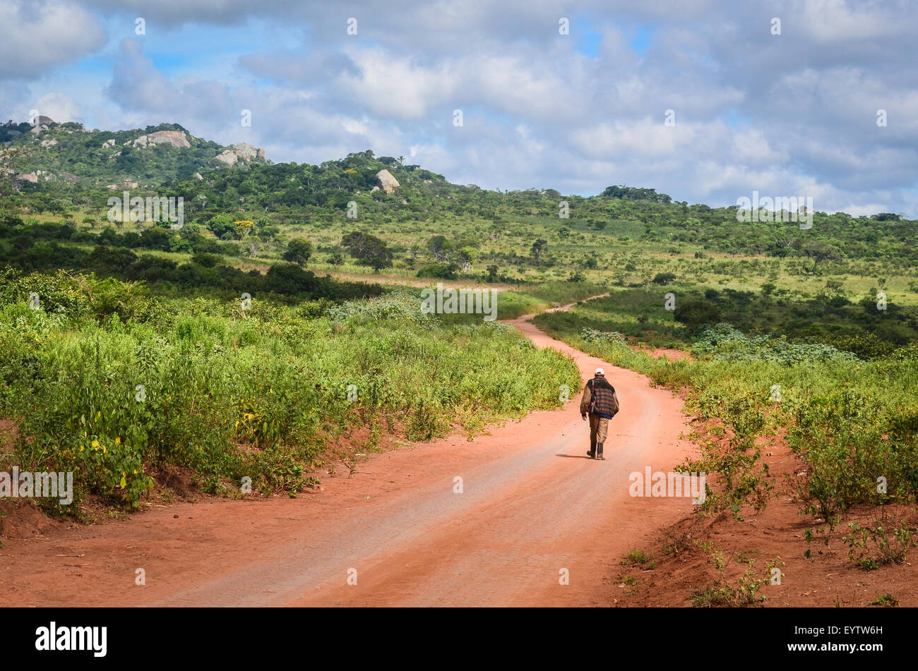 Old man walking alone on a long dirt road in rural Angola Stock Photo ...