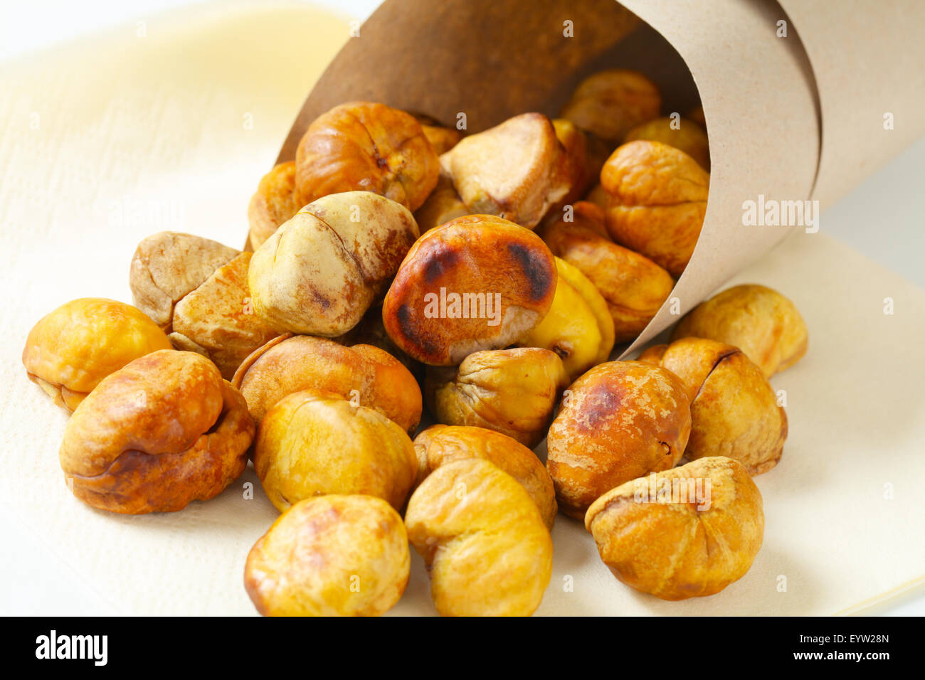 Peeled roasted chestnuts spill out of a paper cone Stock Photo - Alamy
