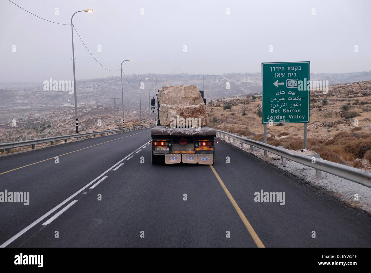 A truck loaded with a huge limestone rock driving through Highway 60 in ...