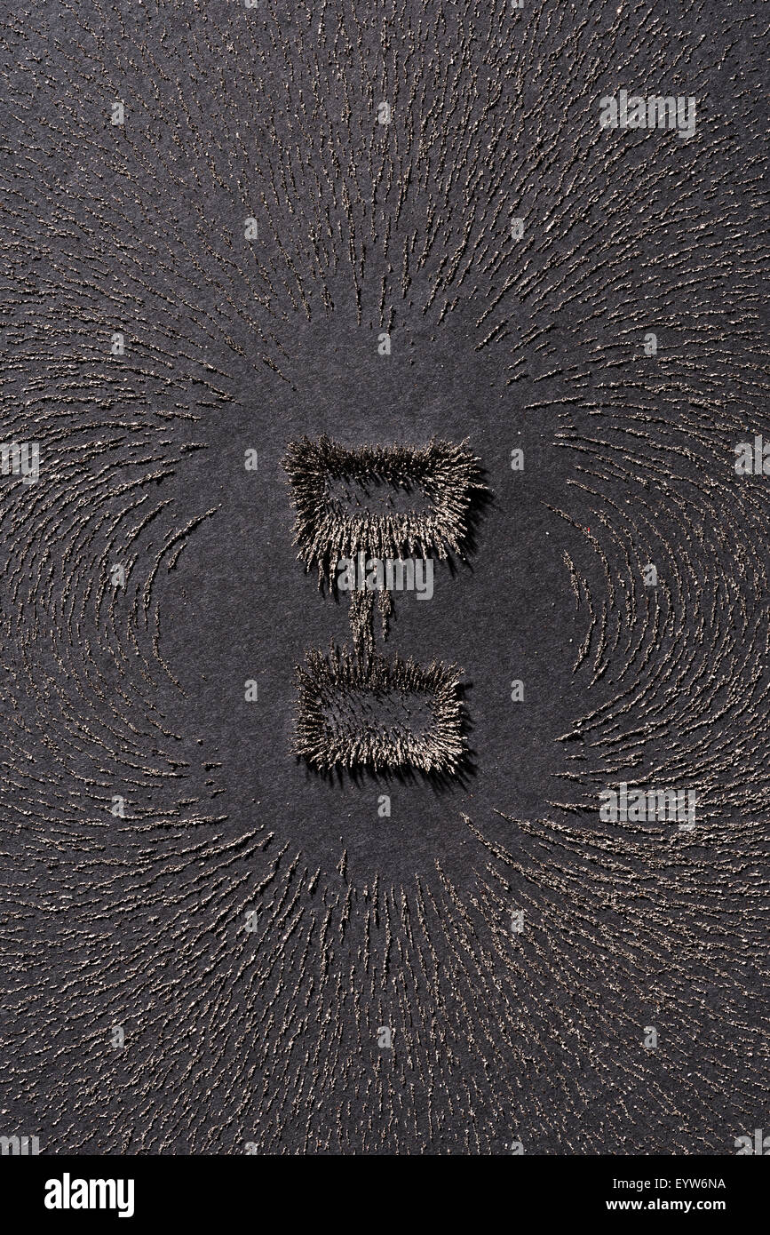 Attraction and repulsion iron metal particles align up along the ...