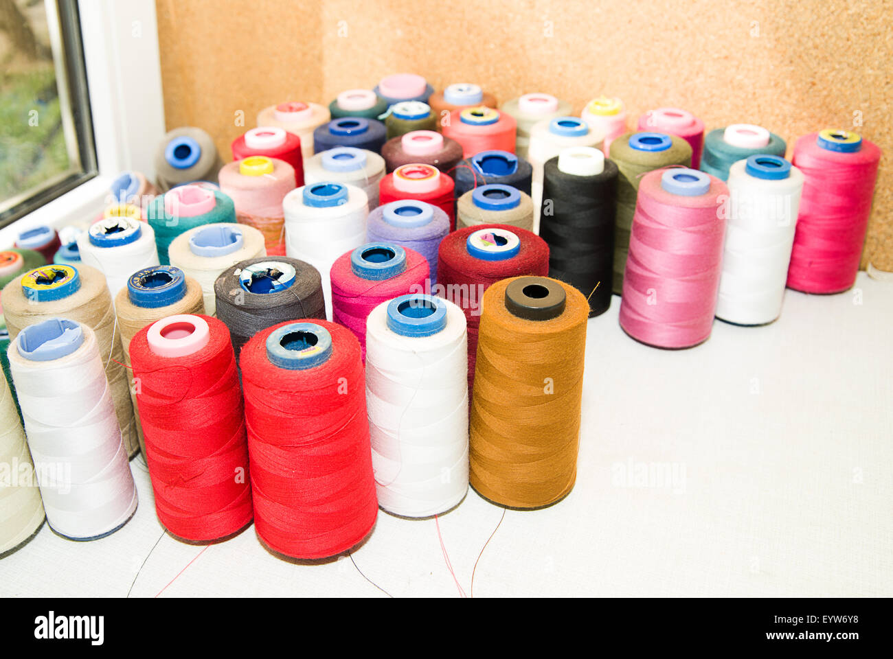 Many reels of colored threads standing on the table Stock Photo - Alamy
