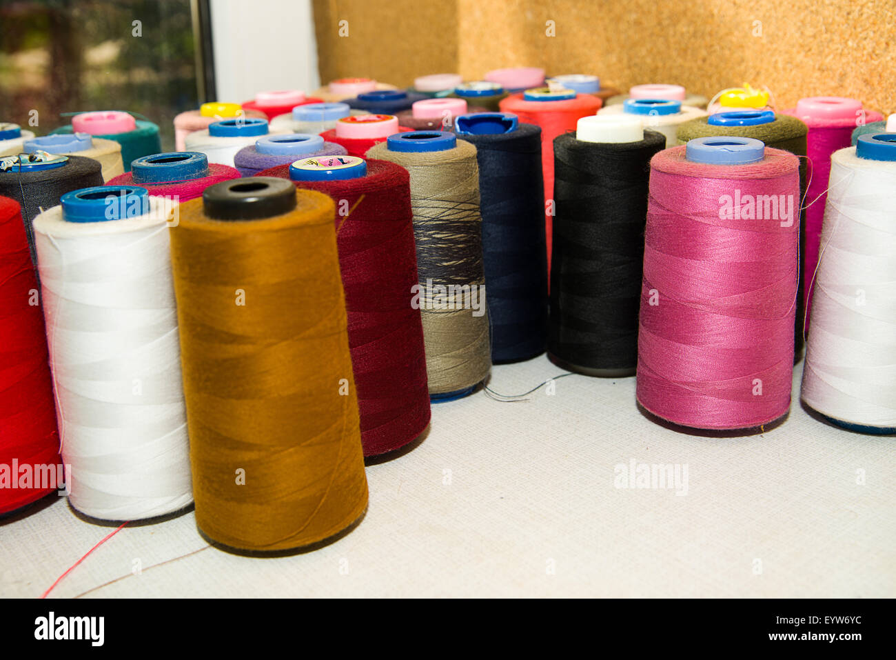 Many reels of colored threads standing on the table Stock Photo - Alamy