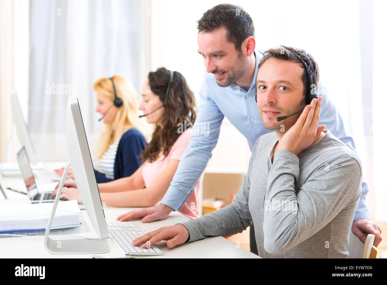 View of a Manager training a young attractive people on computer Stock ...