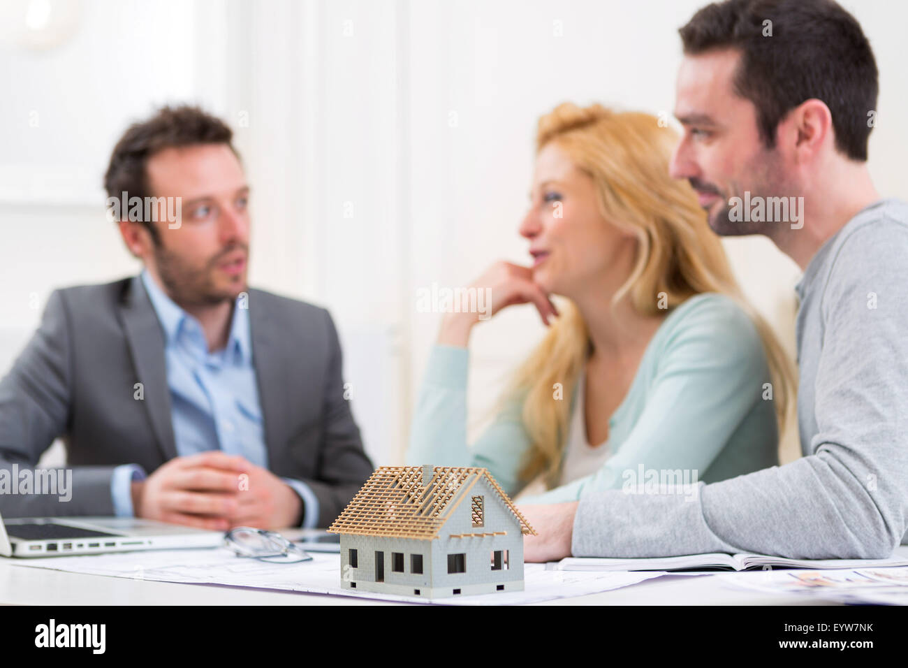 View of a Miniature house in a desk of real estate agent with couple ...