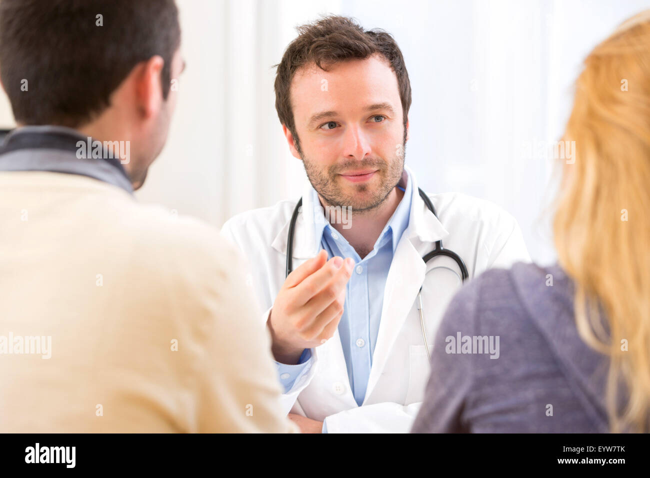 Doctor advising couple hi-res stock photography and images - Alamy