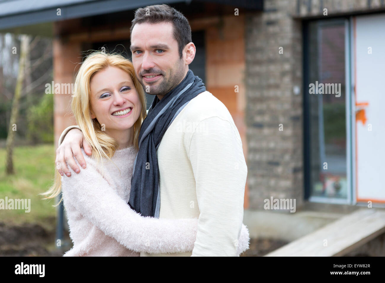 View of a Young happy couple in front of their future house Stock Photo ...