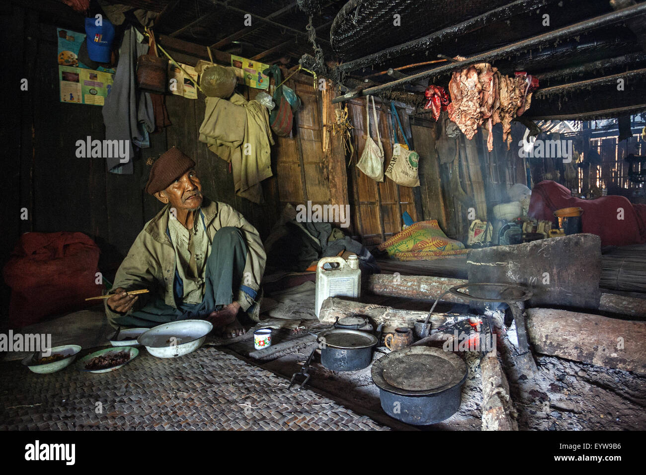 Local man from the tribe of the Loi having a meal in the cooking area ...