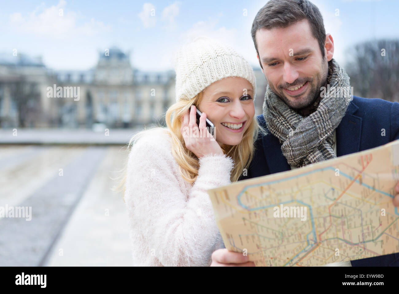 View of a Couple of young attractive tourists watching map Stock Photo ...