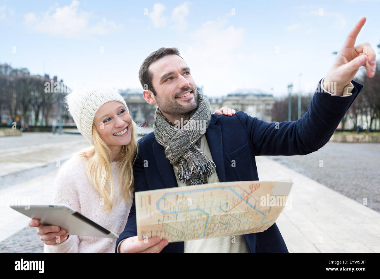 View of a Couple of young attractive tourists watching map Stock Photo ...