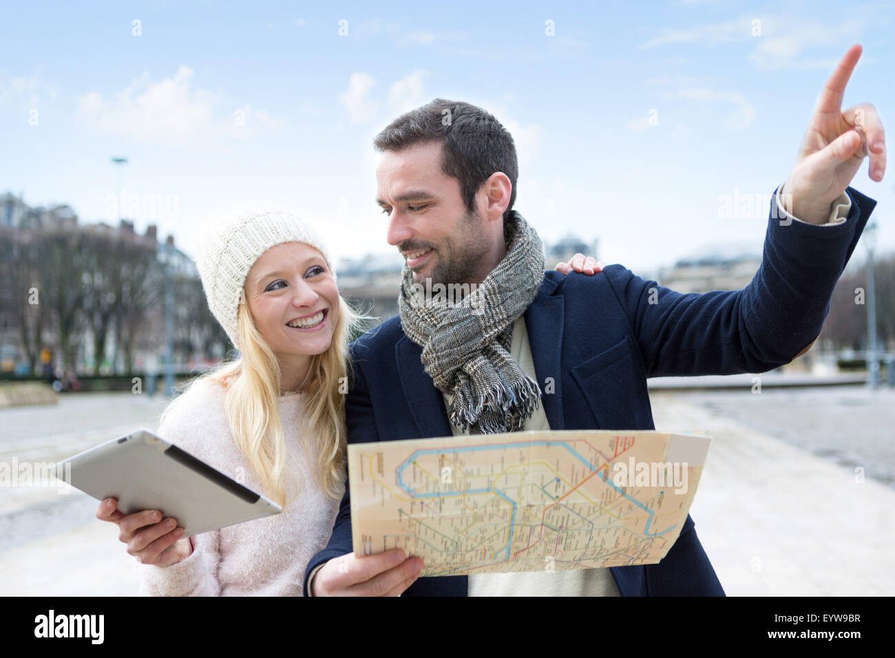 View of a Couple of young attractive tourists watching map Stock Photo ...