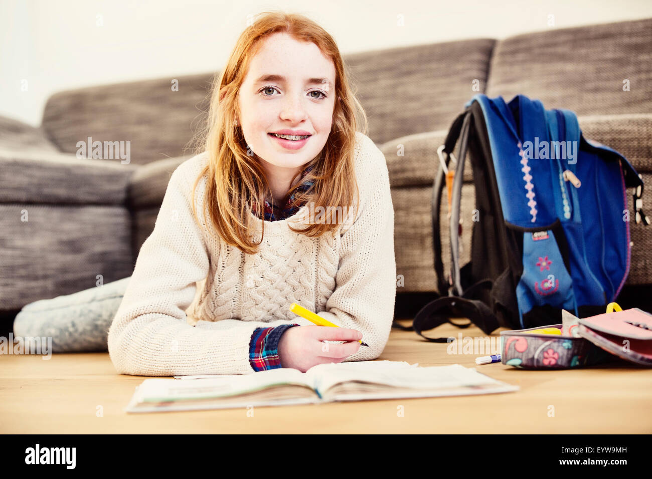Girl doing her homework at home in the living room on the floor Stock ...