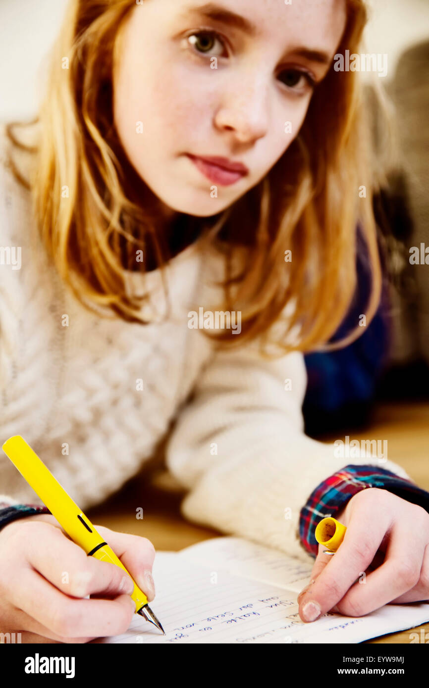 Girl doing her homework on the floor at home Stock Photo - Alamy