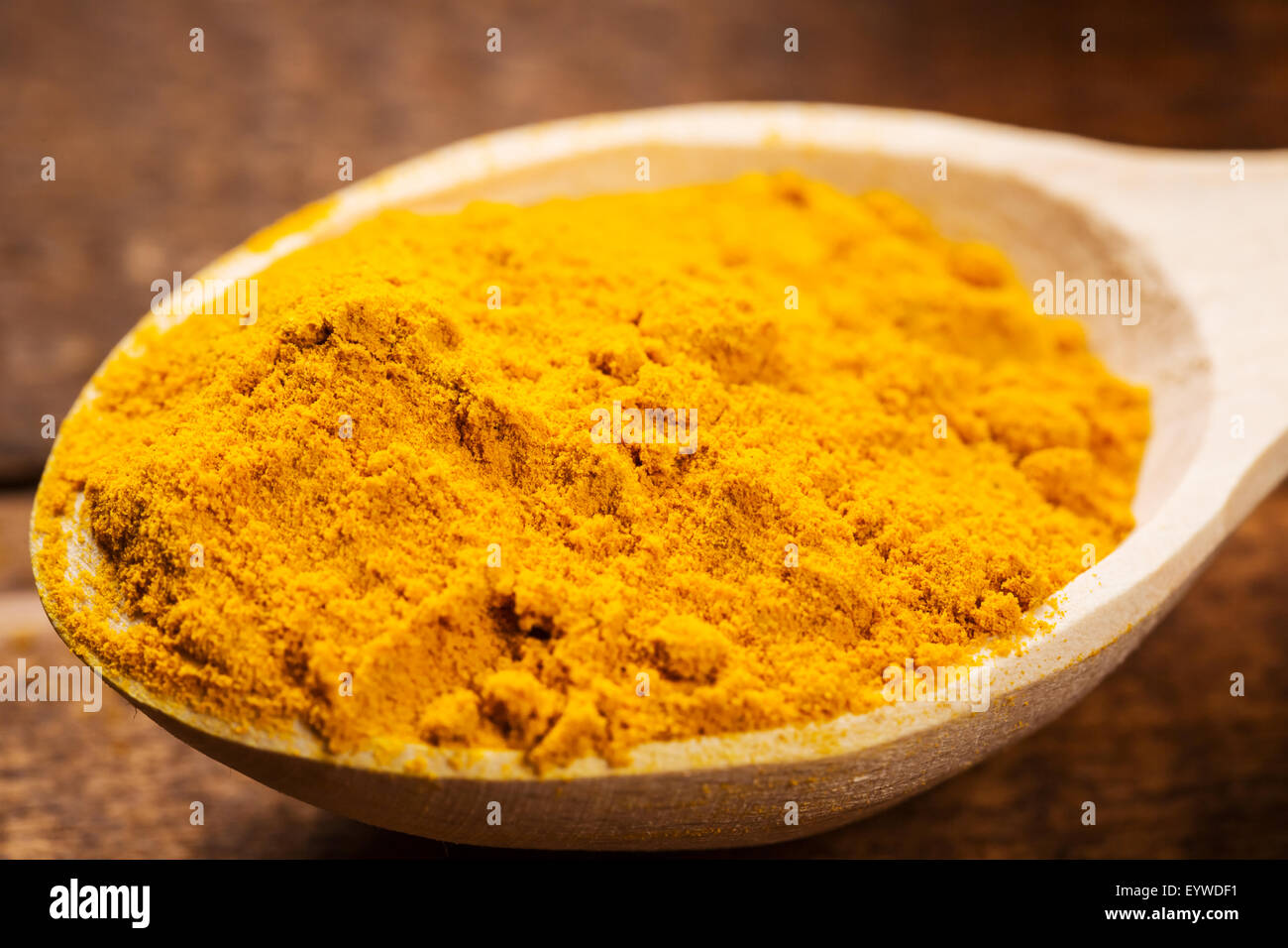 Close up of measuring spoon in pile of organic turmeric (curcuma ...