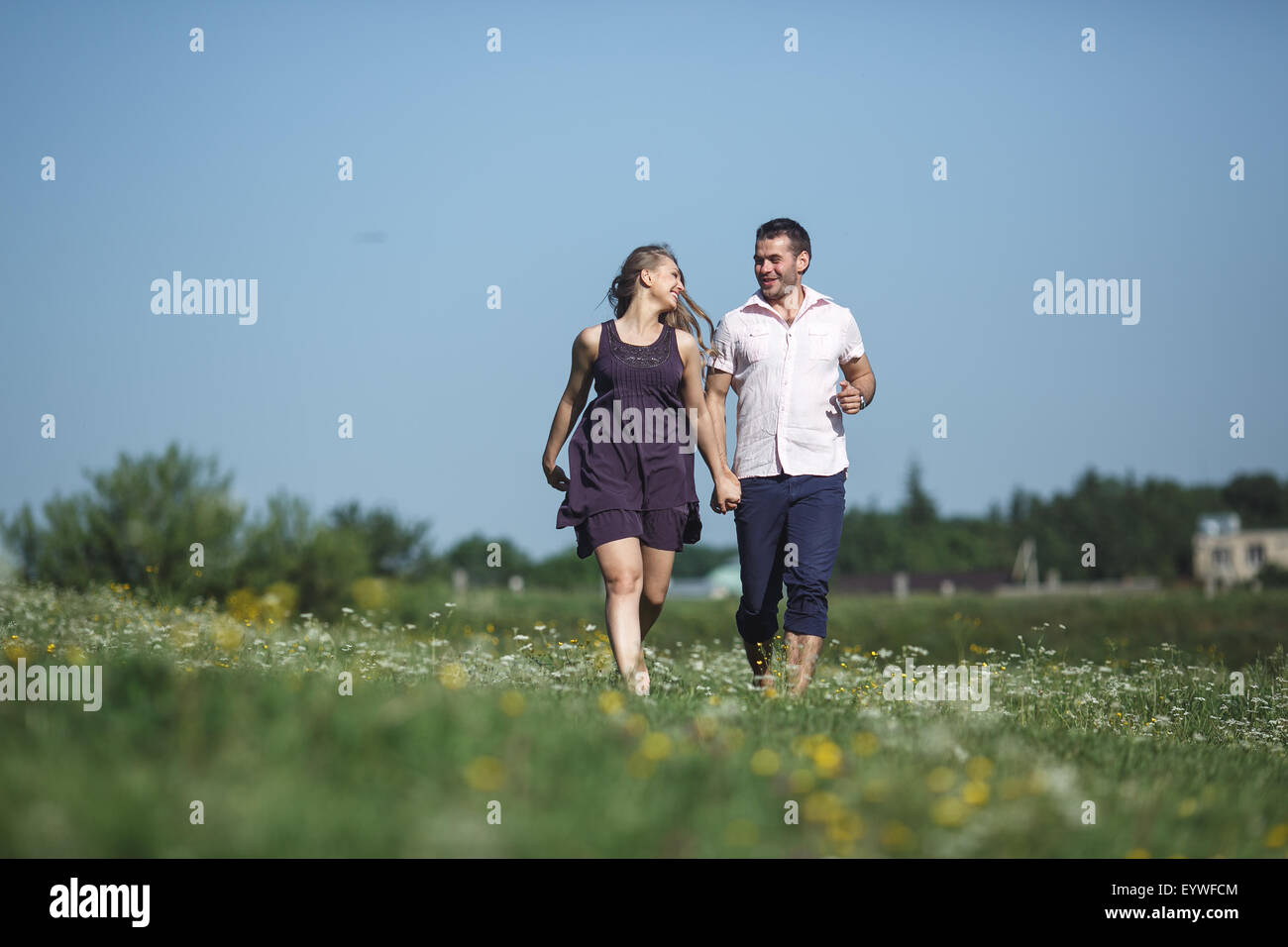 Couple running in field and have fun Stock Photo - Alamy