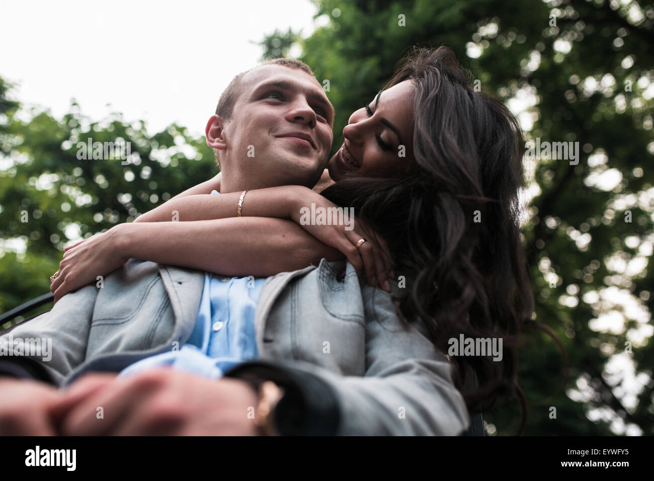 Young European couple cuddling on a park bench Stock Photo - Alamy