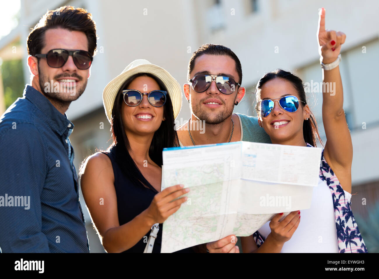 Portrait of group friends use their map in the street Stock Photo - Alamy