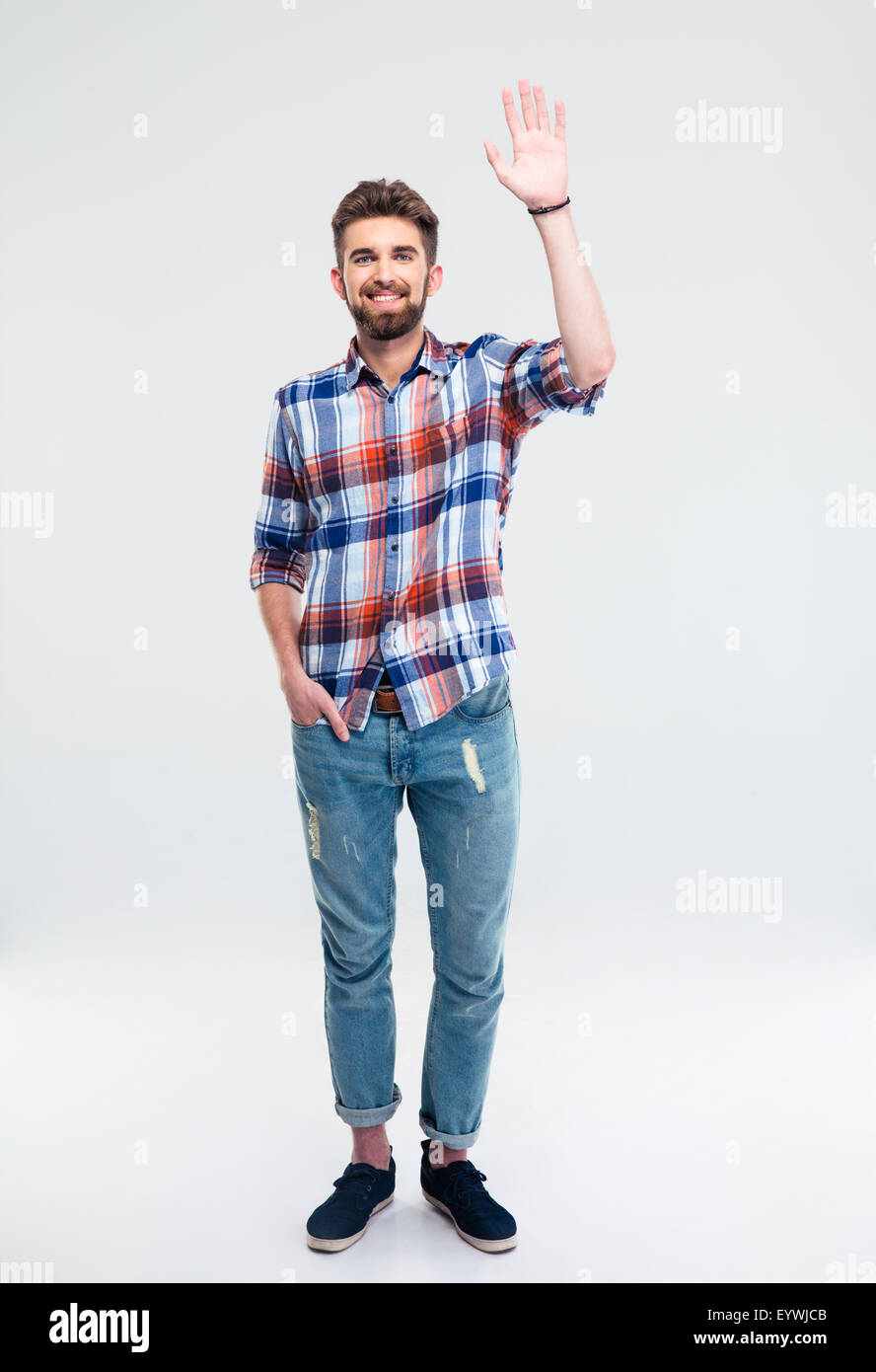 Full length portrait of a young man showing greeting gesture isolated ...