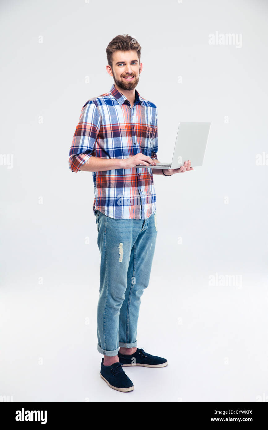 Full length portrait of a happy man standing with laptop computer ...