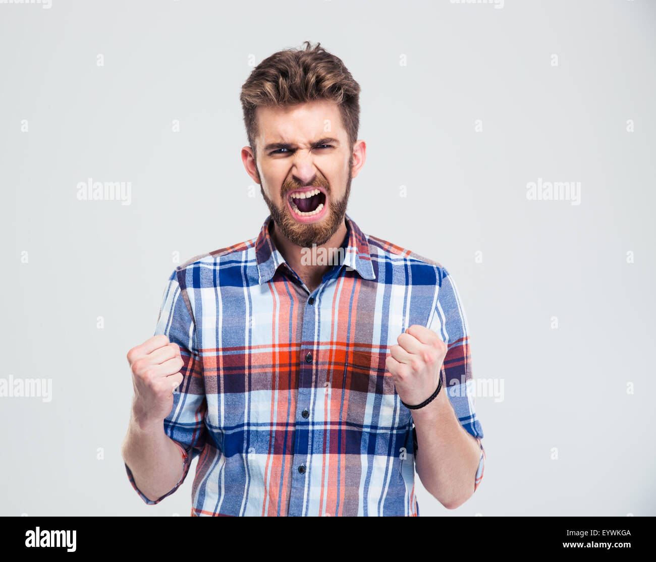 Angry man shouting isolated on a white background. Looking at camera ...