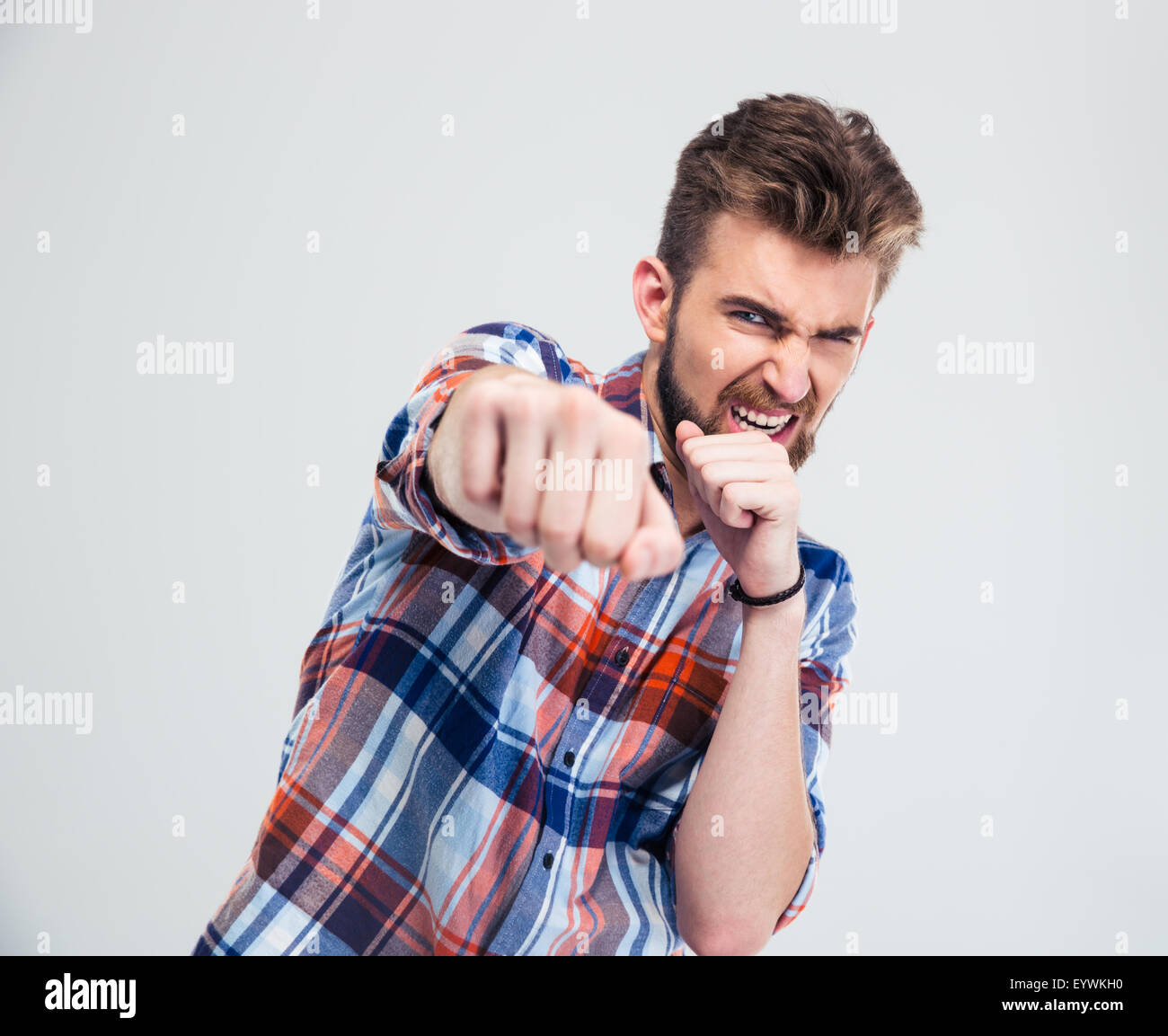 Angry young man hitting at camera isolated on a white background Stock ...