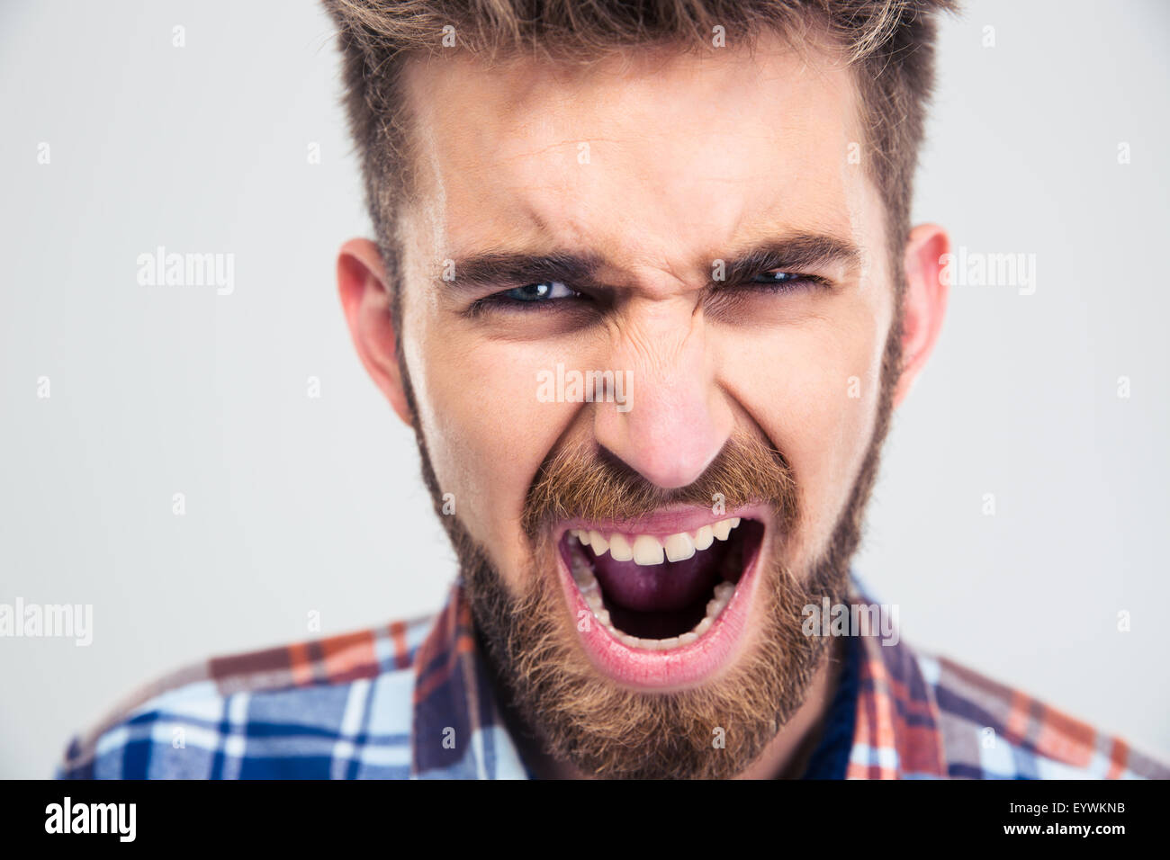 Portrait of a young man screaming isolated on a white background ...