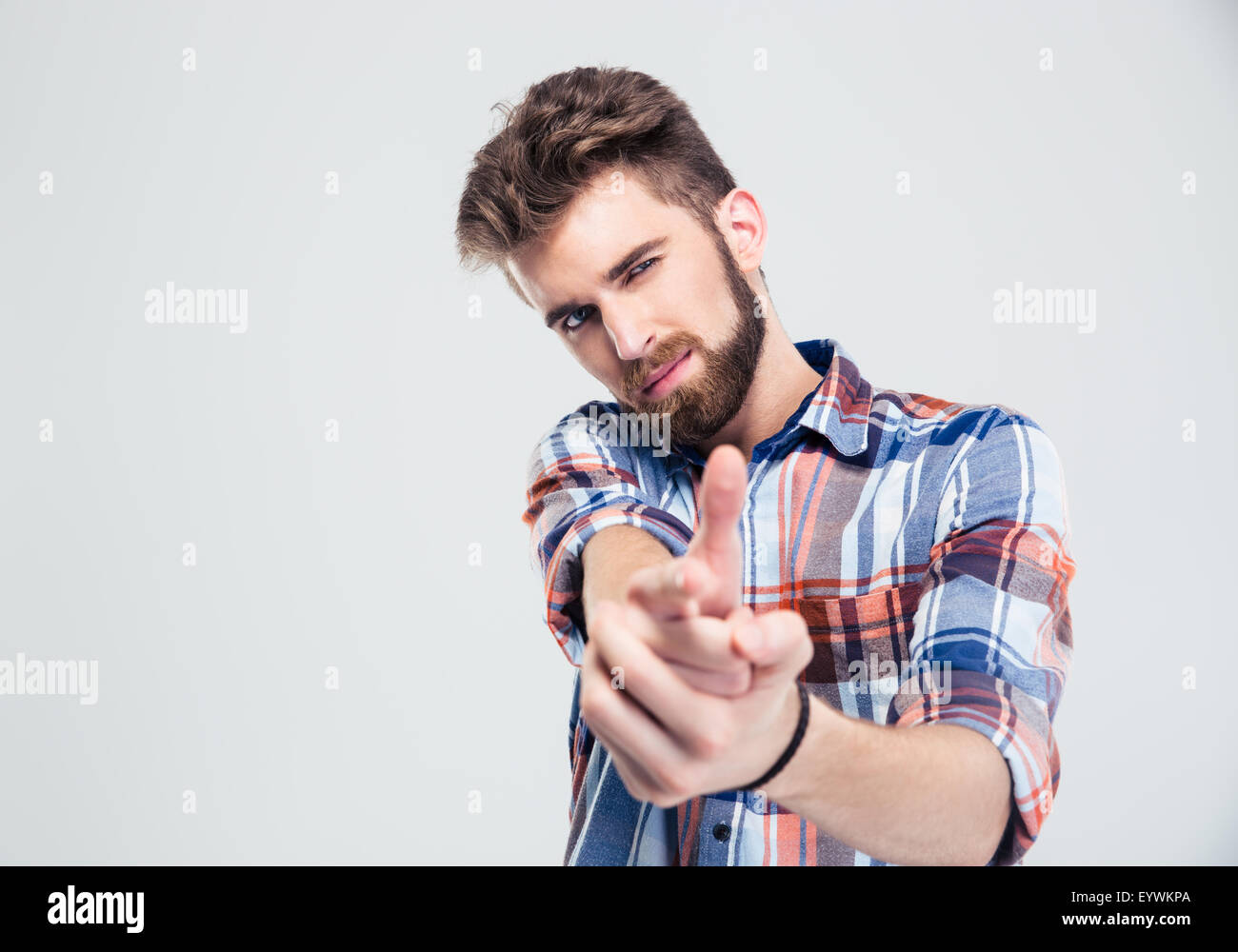 Handsome young man showing gun gesture with hands isolated on a white ...
