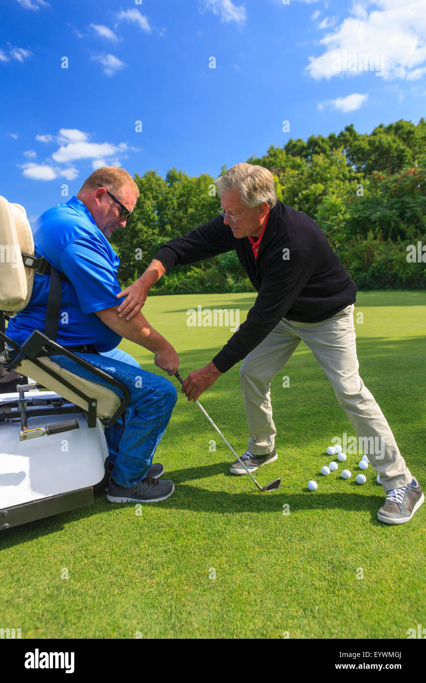 Man with a spinal cord injury in an adaptive cart at golf putting green ...