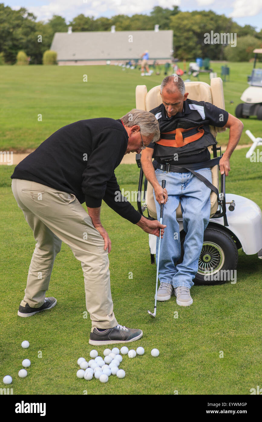 Man with a spinal cord injury in an adaptive cart at golf putting green ...