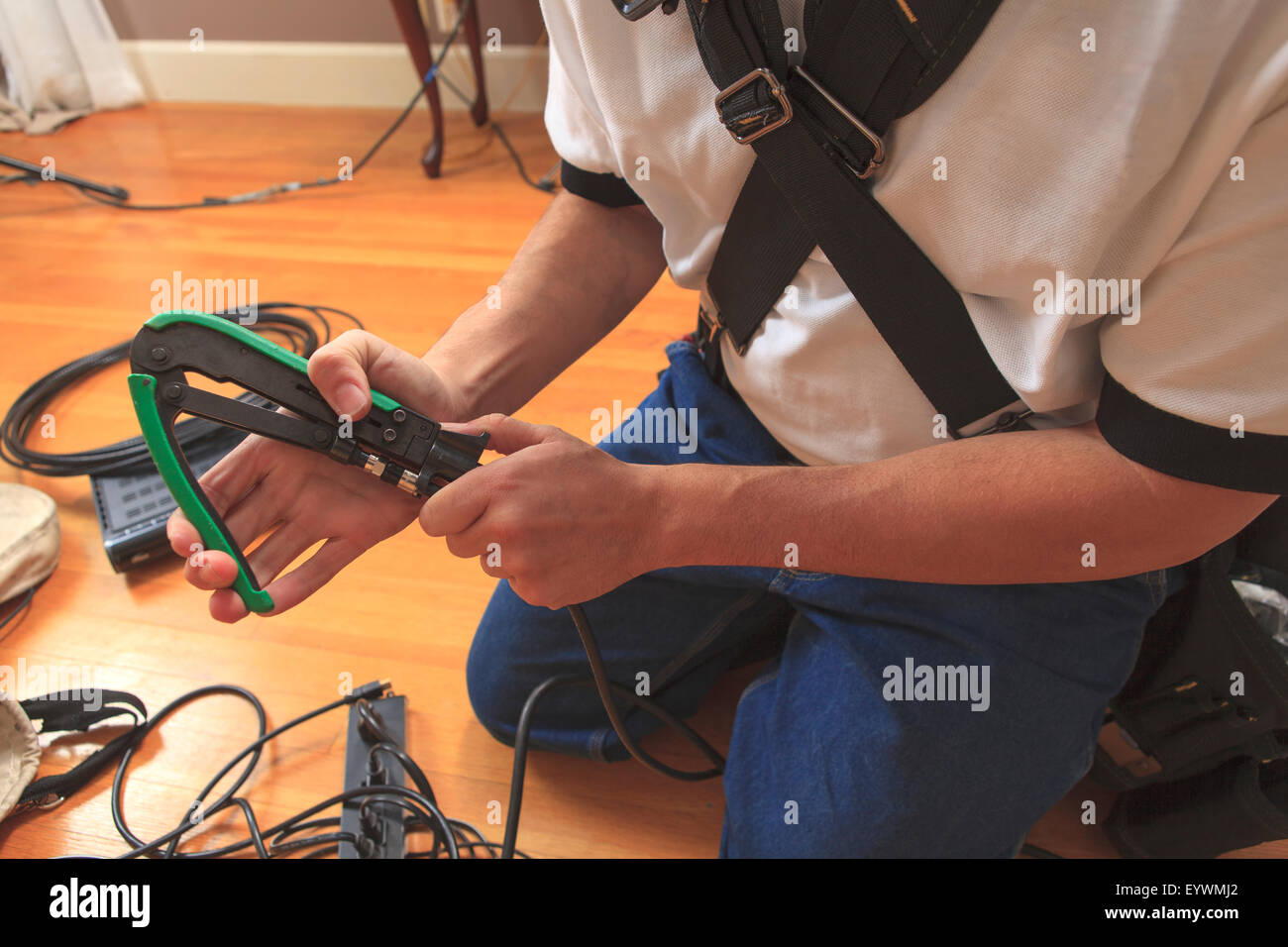 Cable installer using a crimping tool to add a new cable connector to a ...