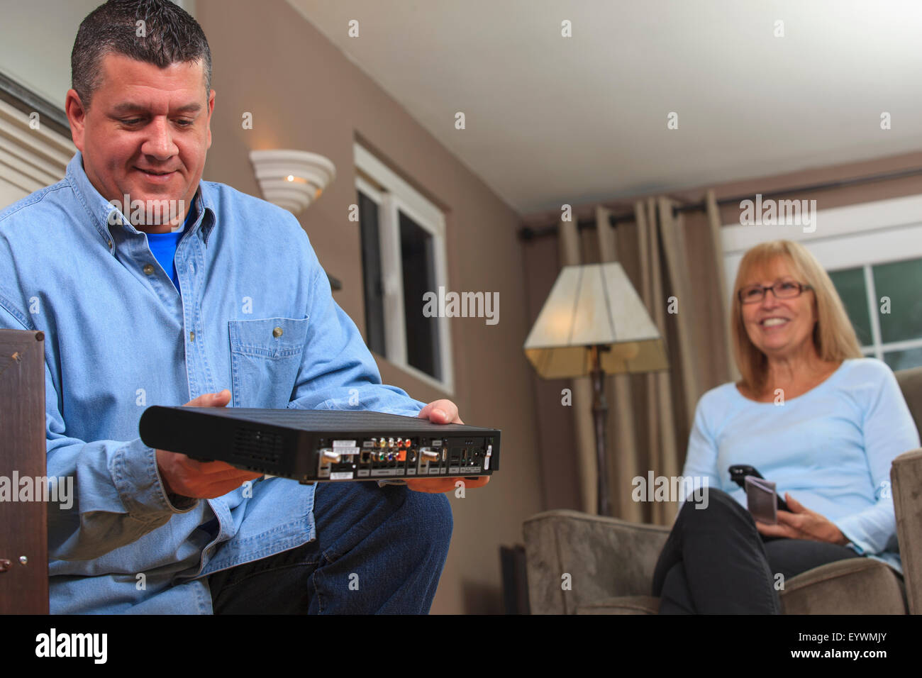 Service man preparing to install a cable box for homeowner Stock Photo ...