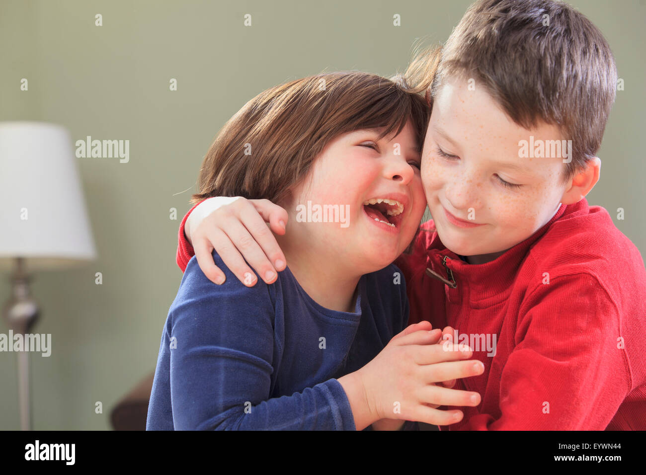 Little girl with Down Syndrome laughing with her brother Stock Photo ...