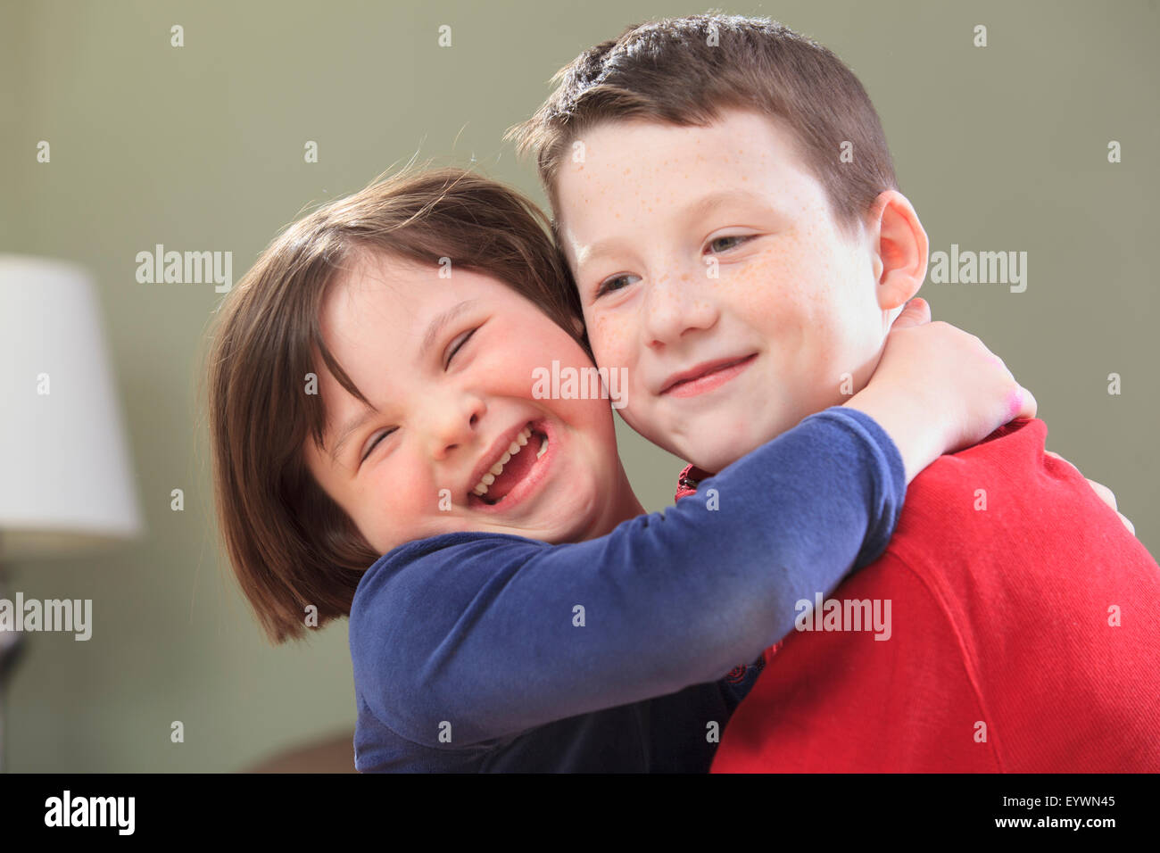 Little girl with Down Syndrome laughing with her brother Stock Photo ...