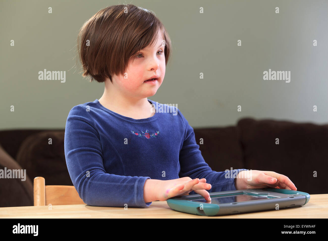 Little girl with Down Syndrome playing an electronic learning game ...