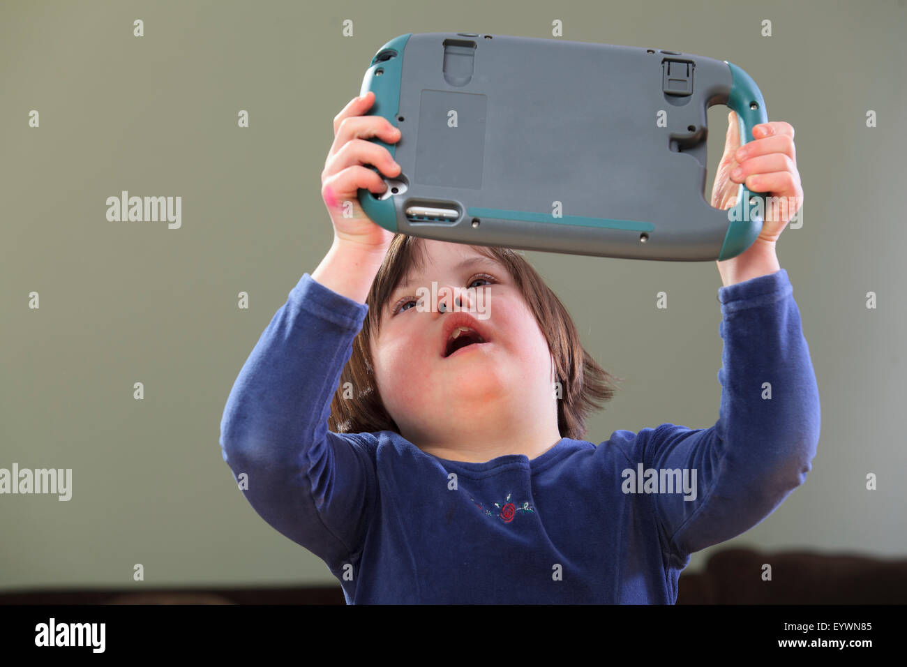 Little girl with Down Syndrome playing an electronic learning game ...