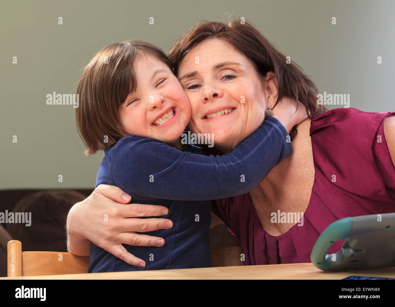 Little girl with Down Syndrome hugging her Mom Stock Photo - Alamy