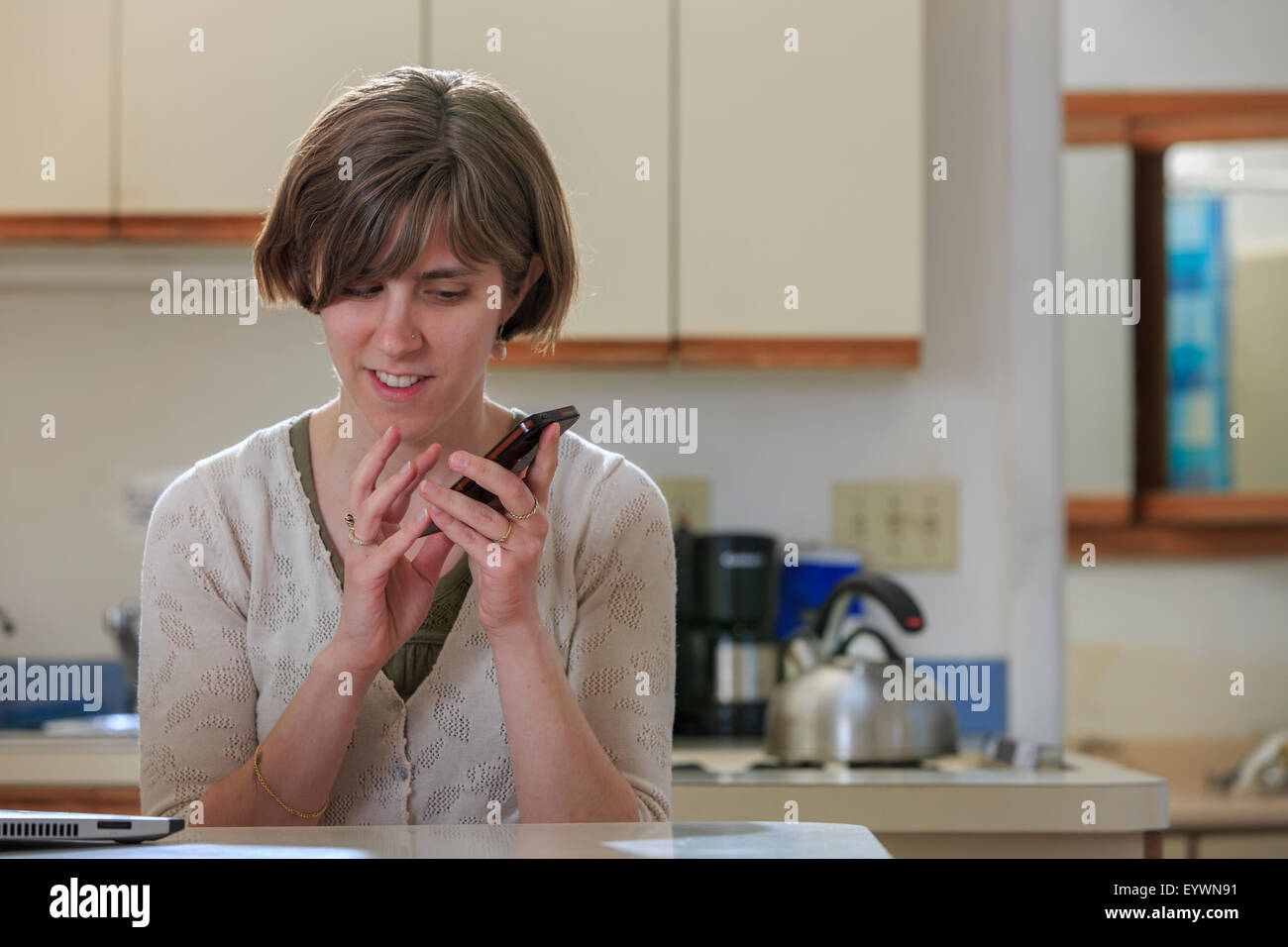 Blind woman using assistive technology to listen to her cell phone ...