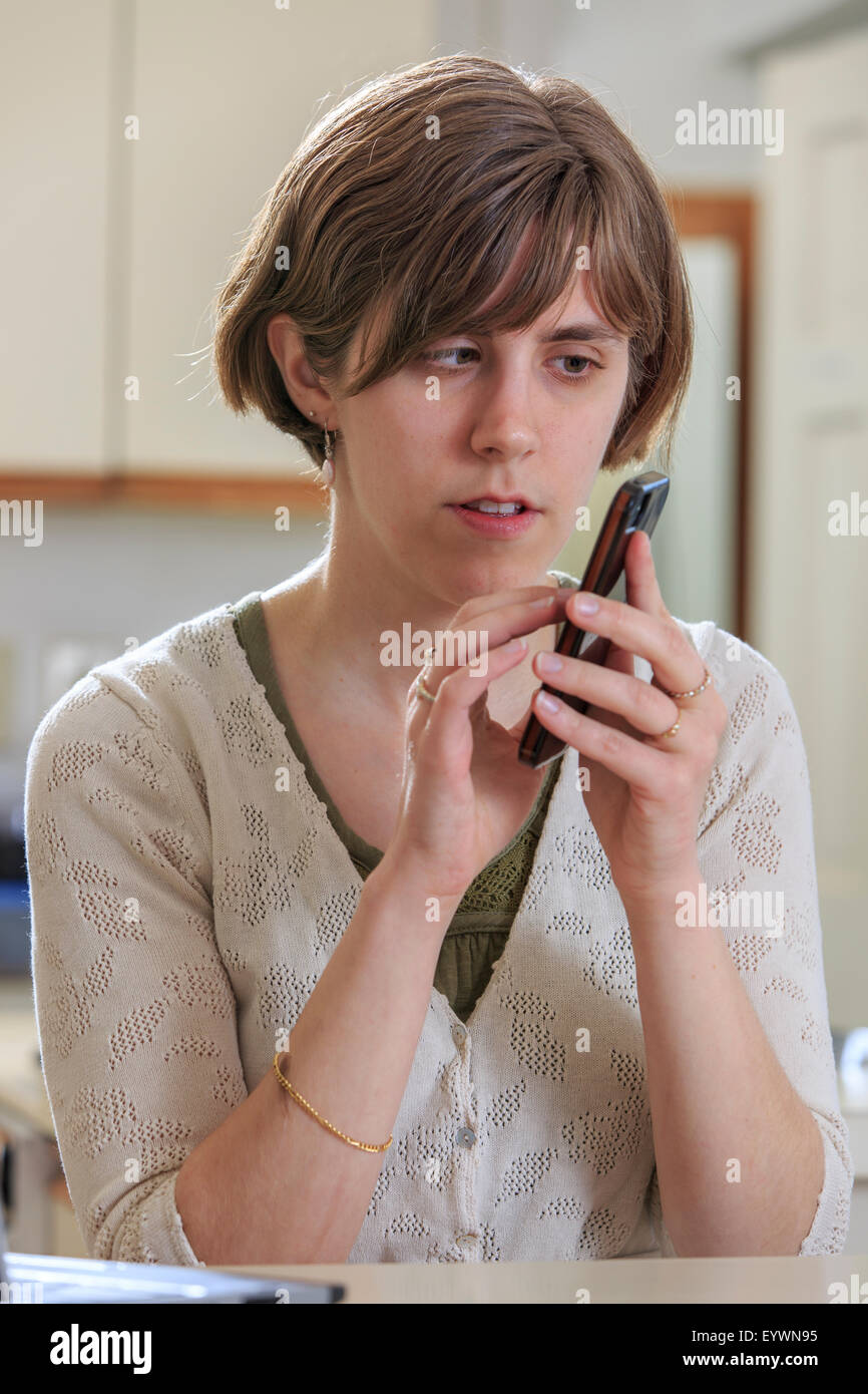 Blind woman using assistive technology to listen to texts on her cell ...