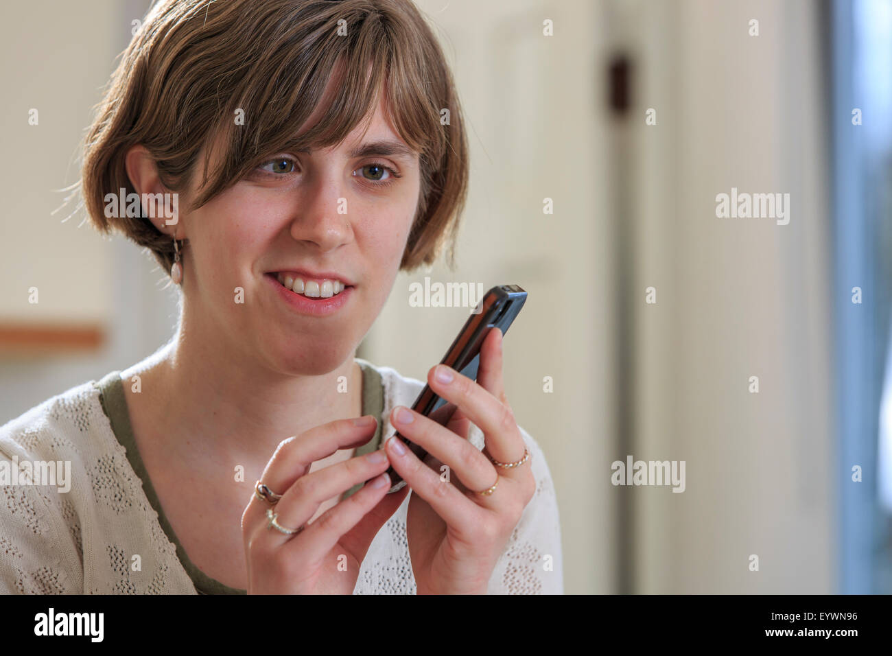 Blind woman using assistive technology to listen to texts on her cell ...