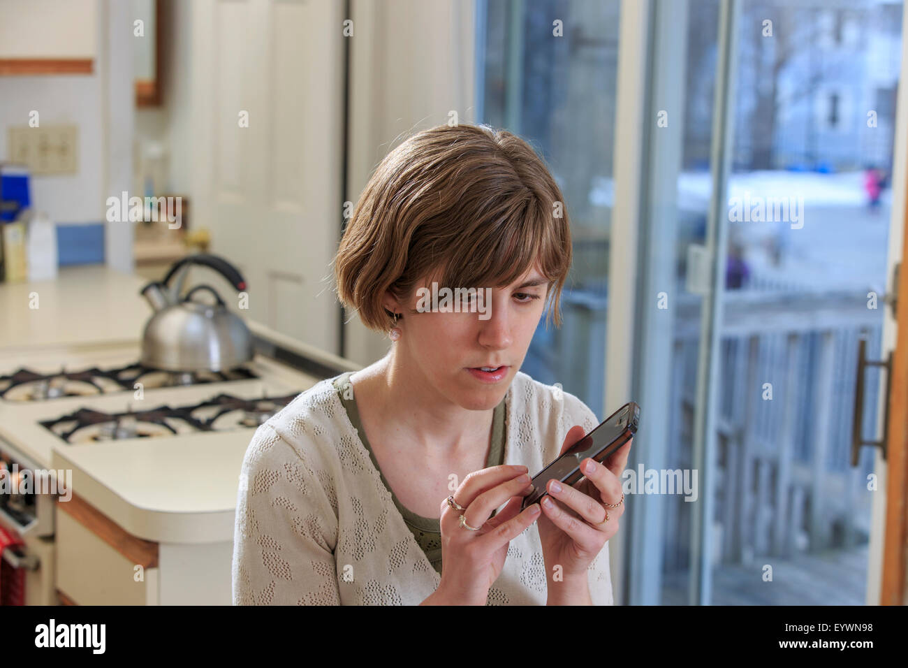 Blind woman using assistive technology to listen to her cell phone ...