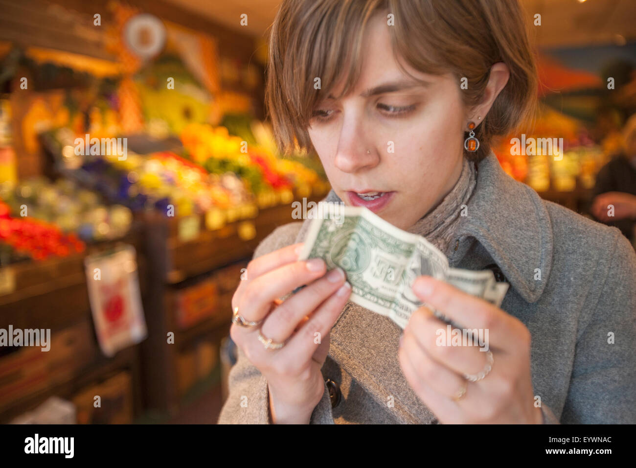 Young blind woman pulling out money to pay in a grocery store Stock ...