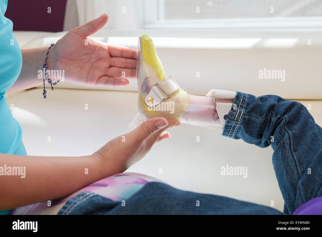 Mother putting leg brace on small daughter with Cerebral Palsy Stock ...