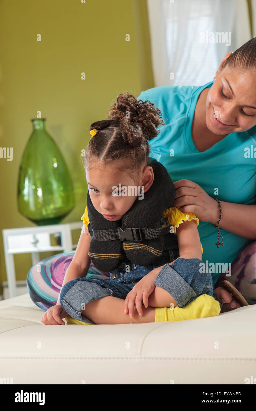 Mother putting brace on small daughter with Cerebral Palsy Stock Photo ...
